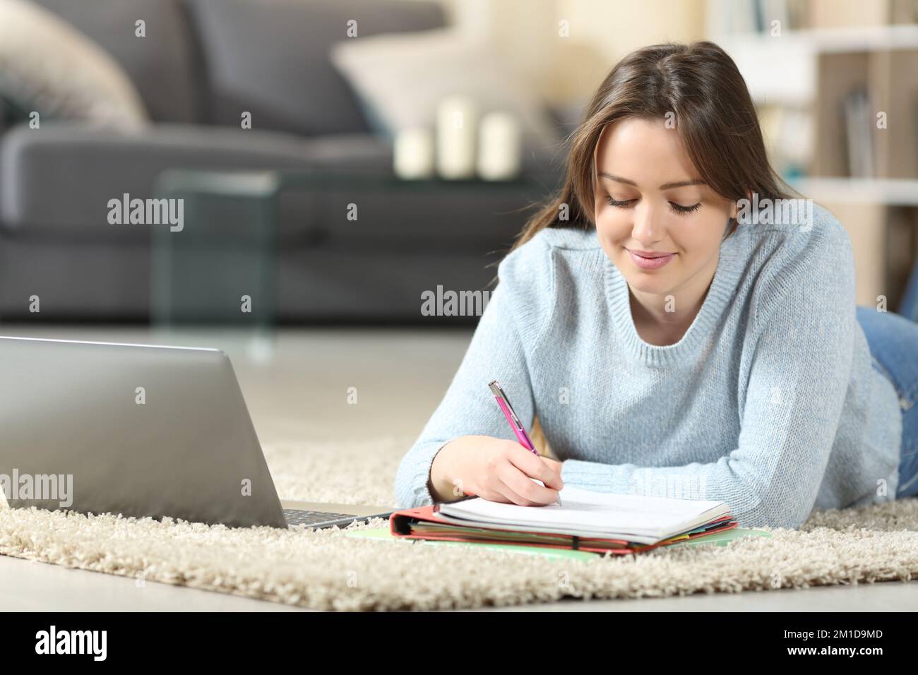 Teen studying lying on the floor taking notes at home Stock Photo - Alamy
