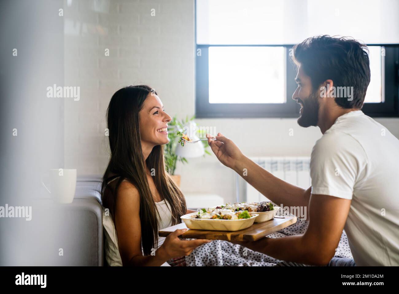 Men brings breakfast to bed for his beautiful girlfriend. Couple, love ...