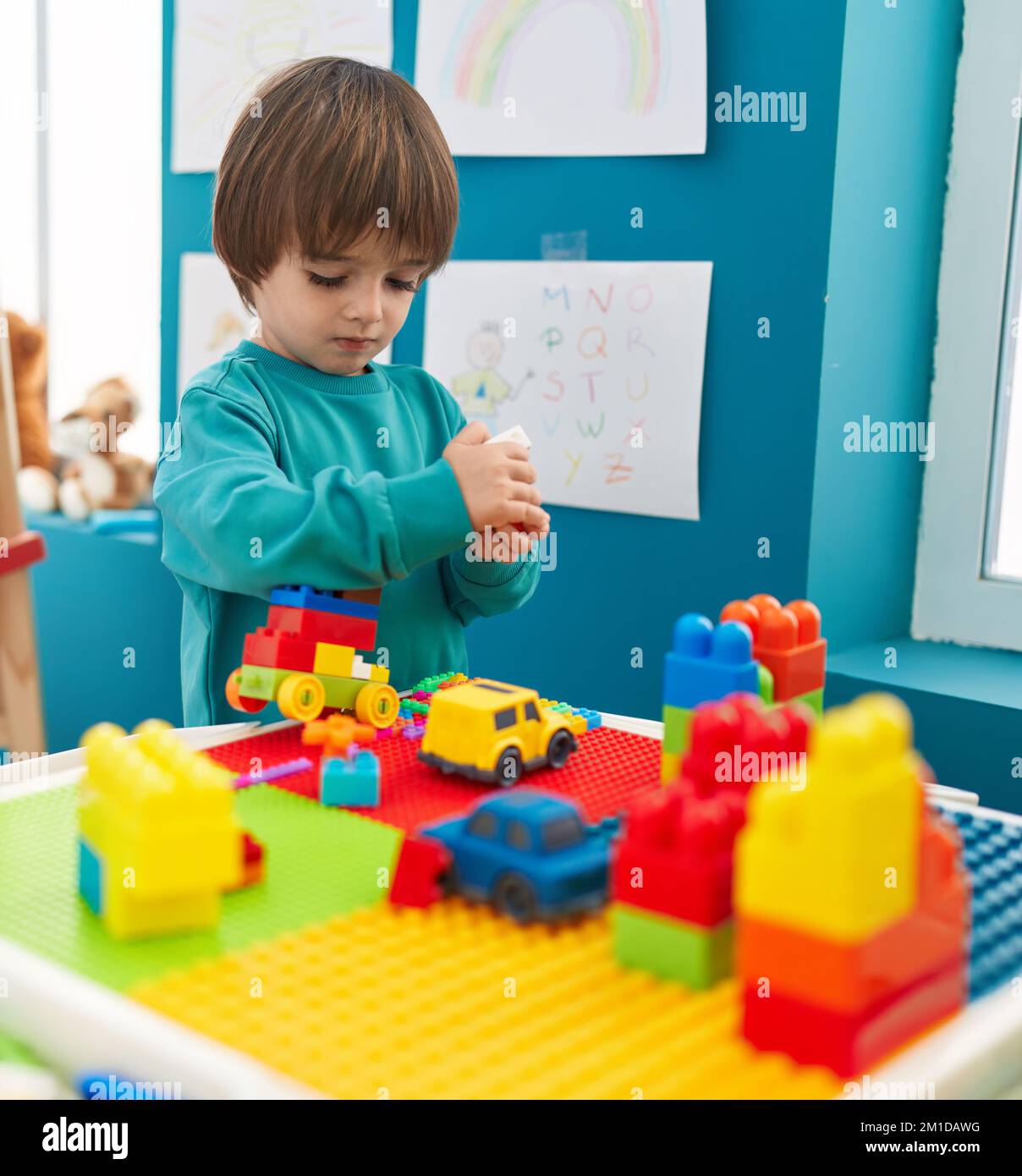 Adorable toddler playing with construction blocks standing at ...