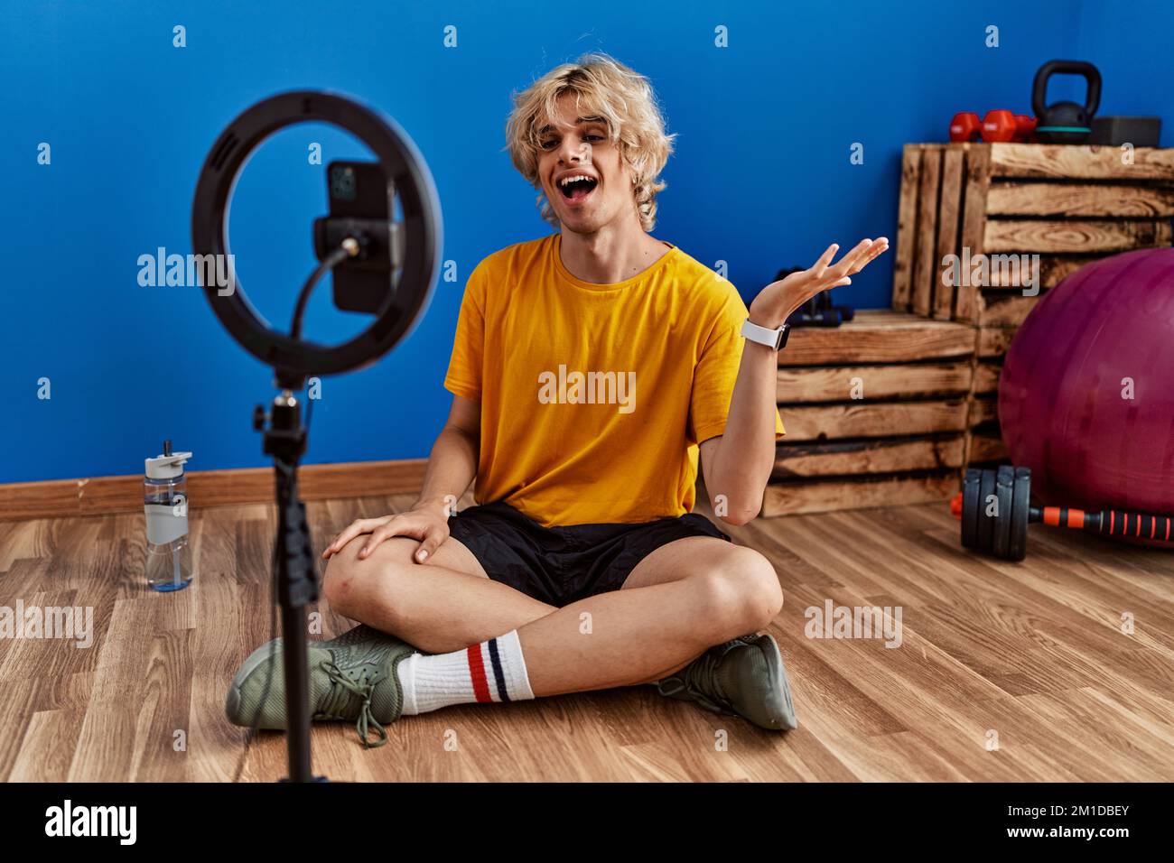Young man recording training tutorial at the gym celebrating ...