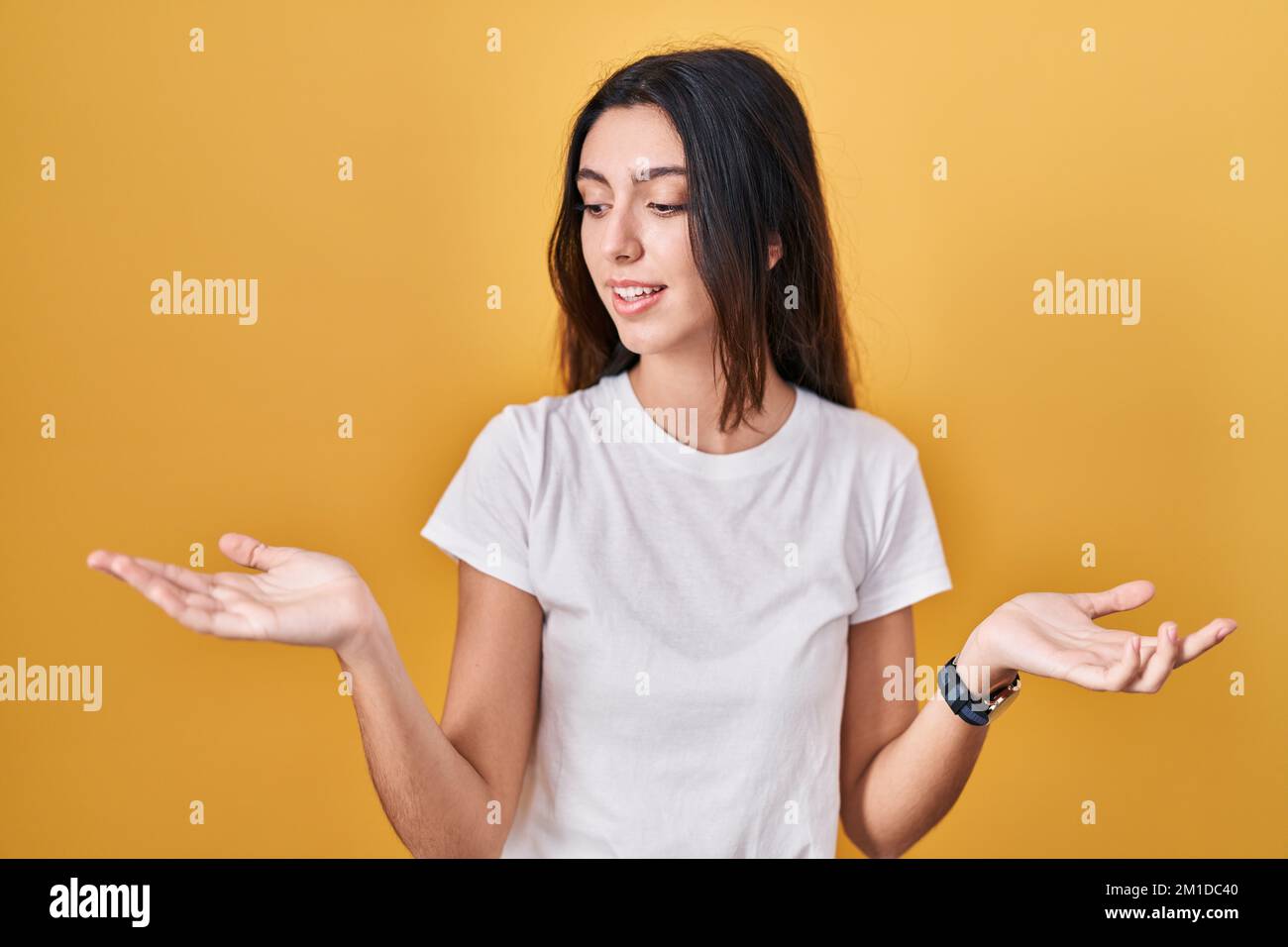 Young beautiful woman standing over yellow background smiling showing ...