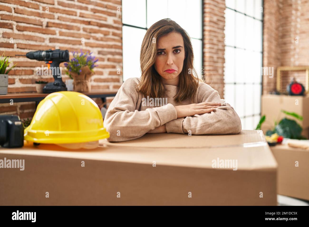 Young woman moving to a new home depressed and worry for distress ...