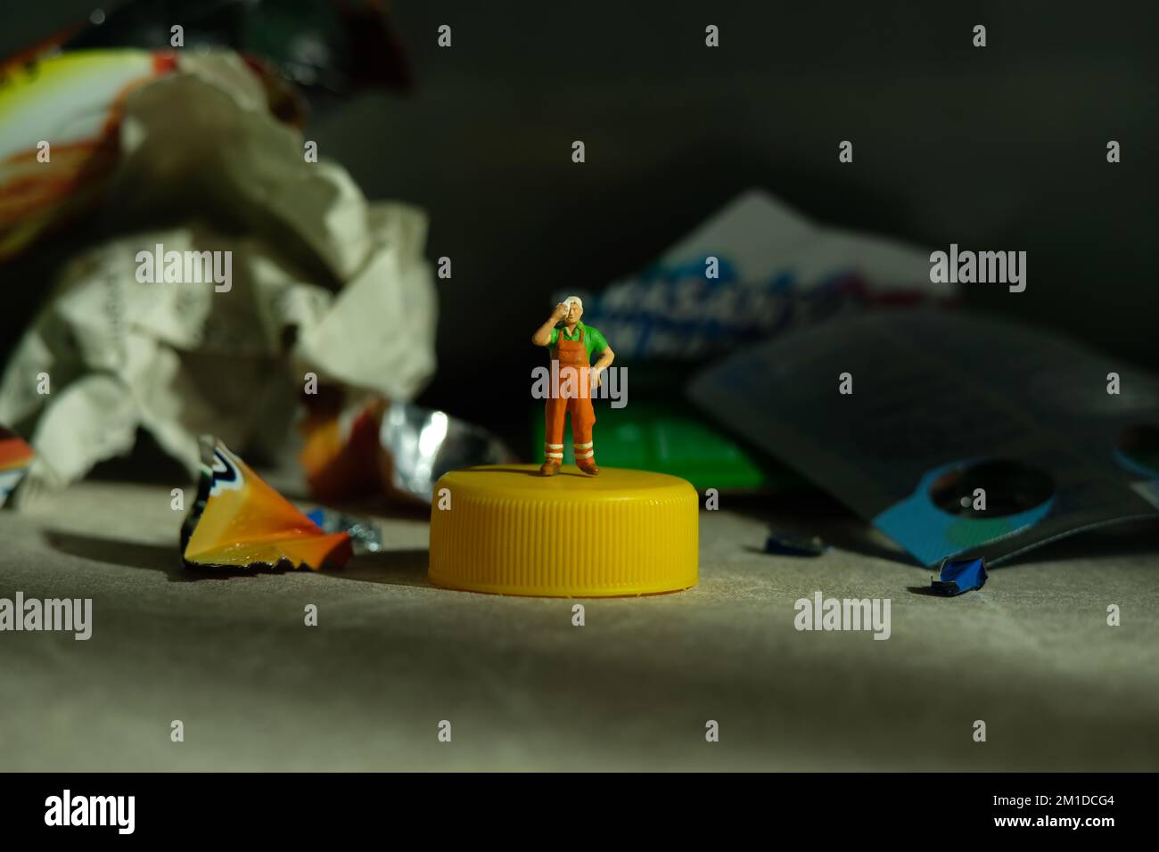 Miniature people toy figure photography. Tired janitor standing above ...