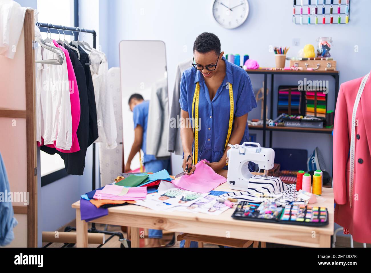 African american woman tailor smiling confident cutting cloth at tailor ...