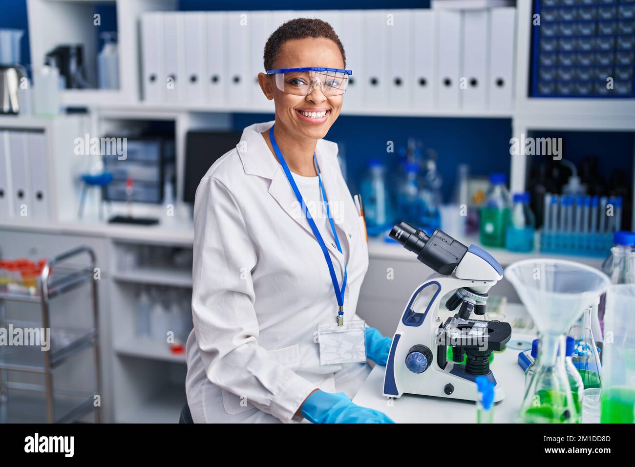 African american woman scientist using microscope at laboratory Stock Photo - Alamy