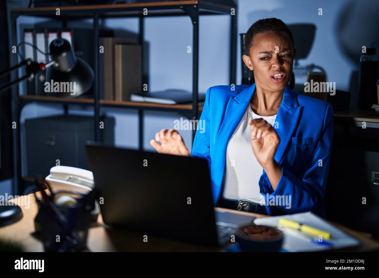Beautiful african american woman working at the office at night ...