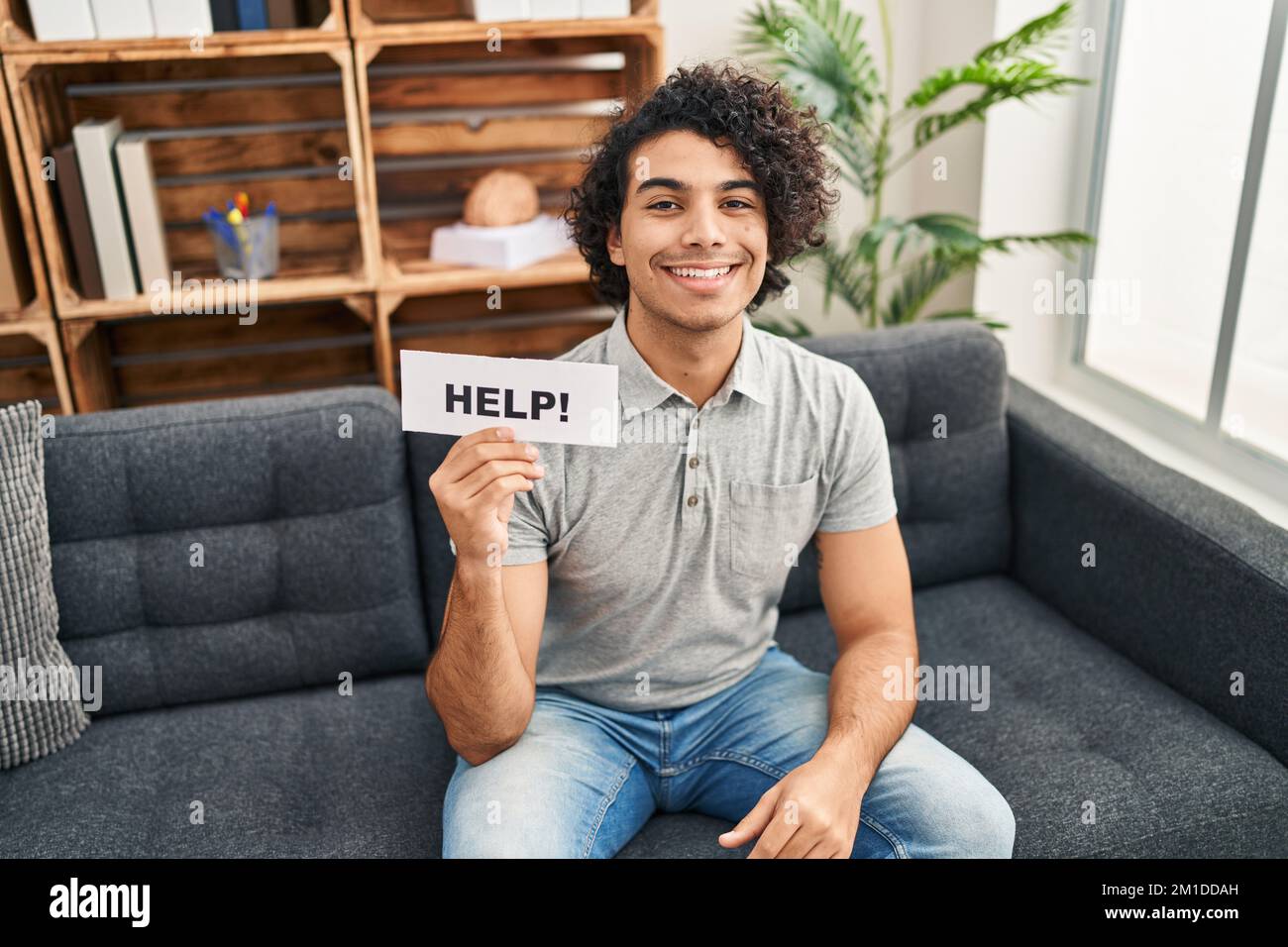 Hispanic man with curly hair asking for help looking positive and happy ...