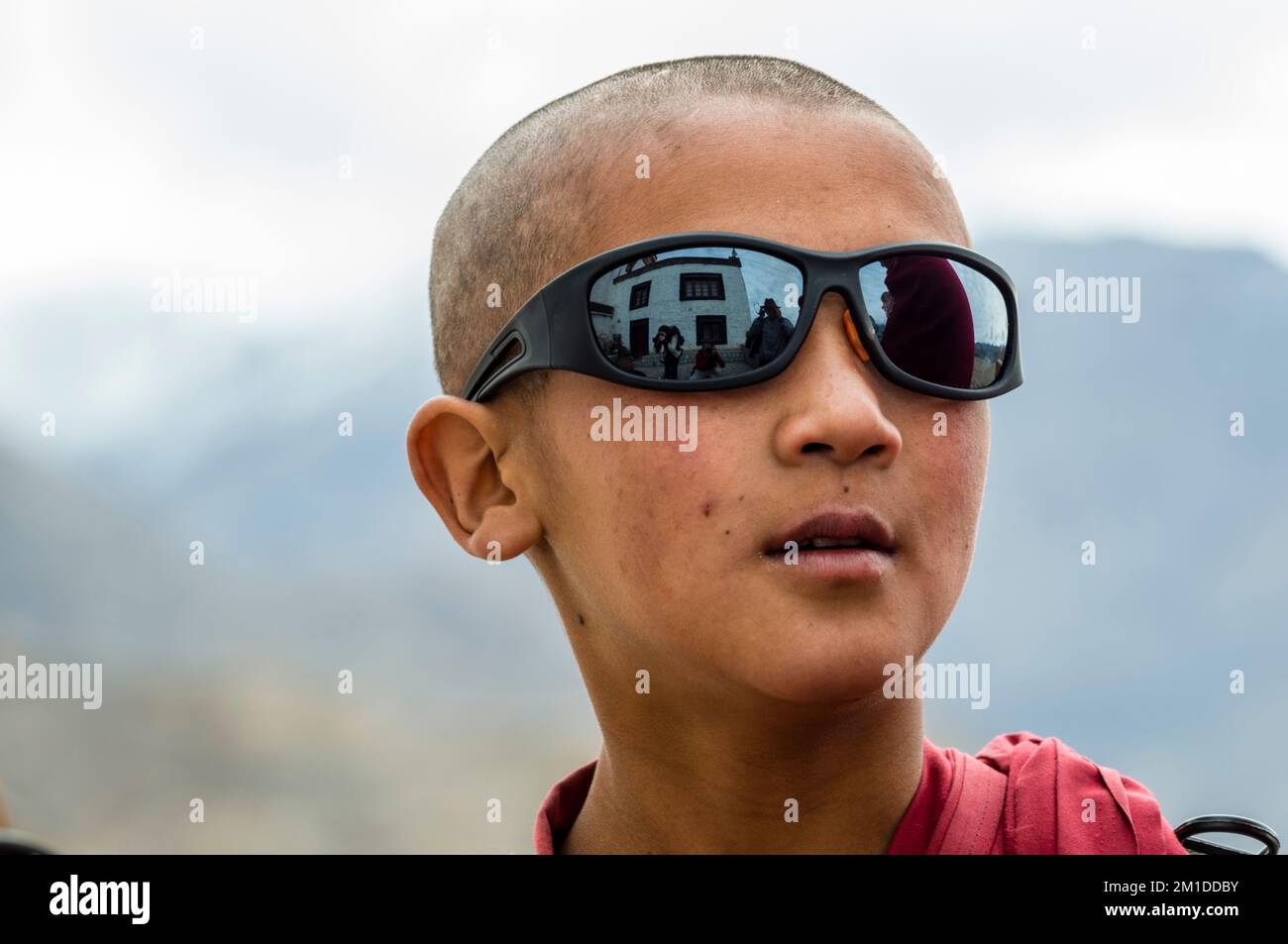 Portrait of a young red dressed monk of Thiksey Gompa, one of the most ...