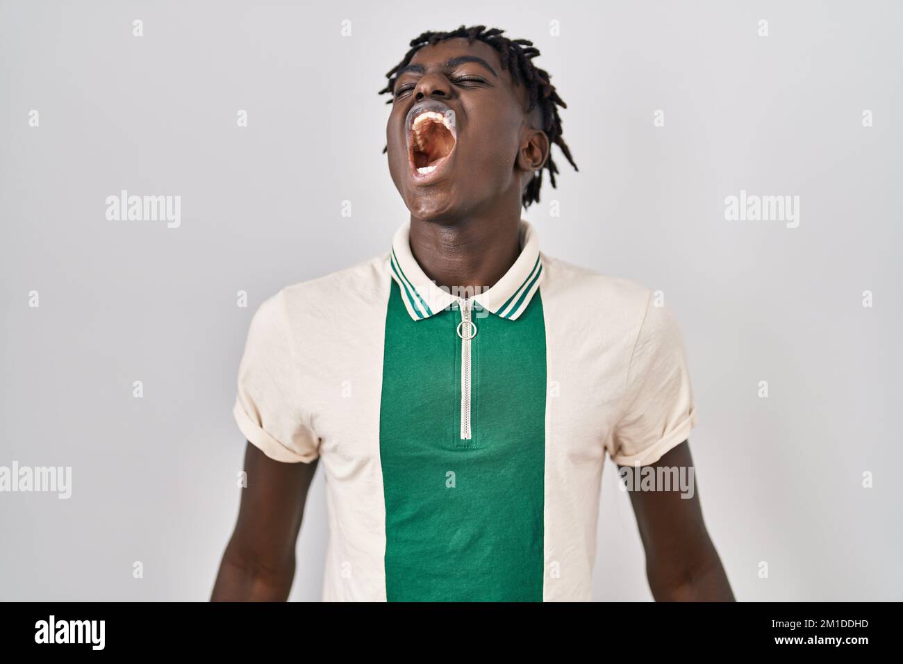 African man with dreadlocks standing over isolated background angry and ...