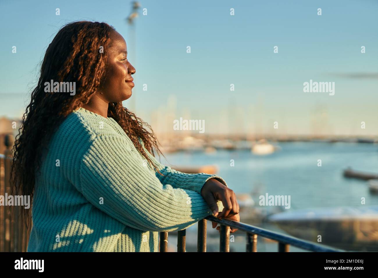 Young african woman smiling happy by marina port Stock Photo - Alamy