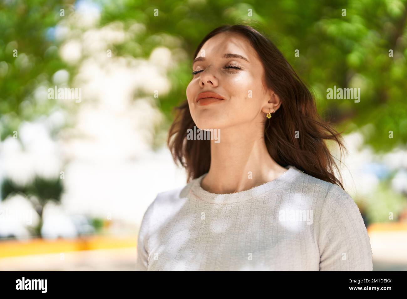 Young woman smiling confident breathing at park Stock Photo - Alamy