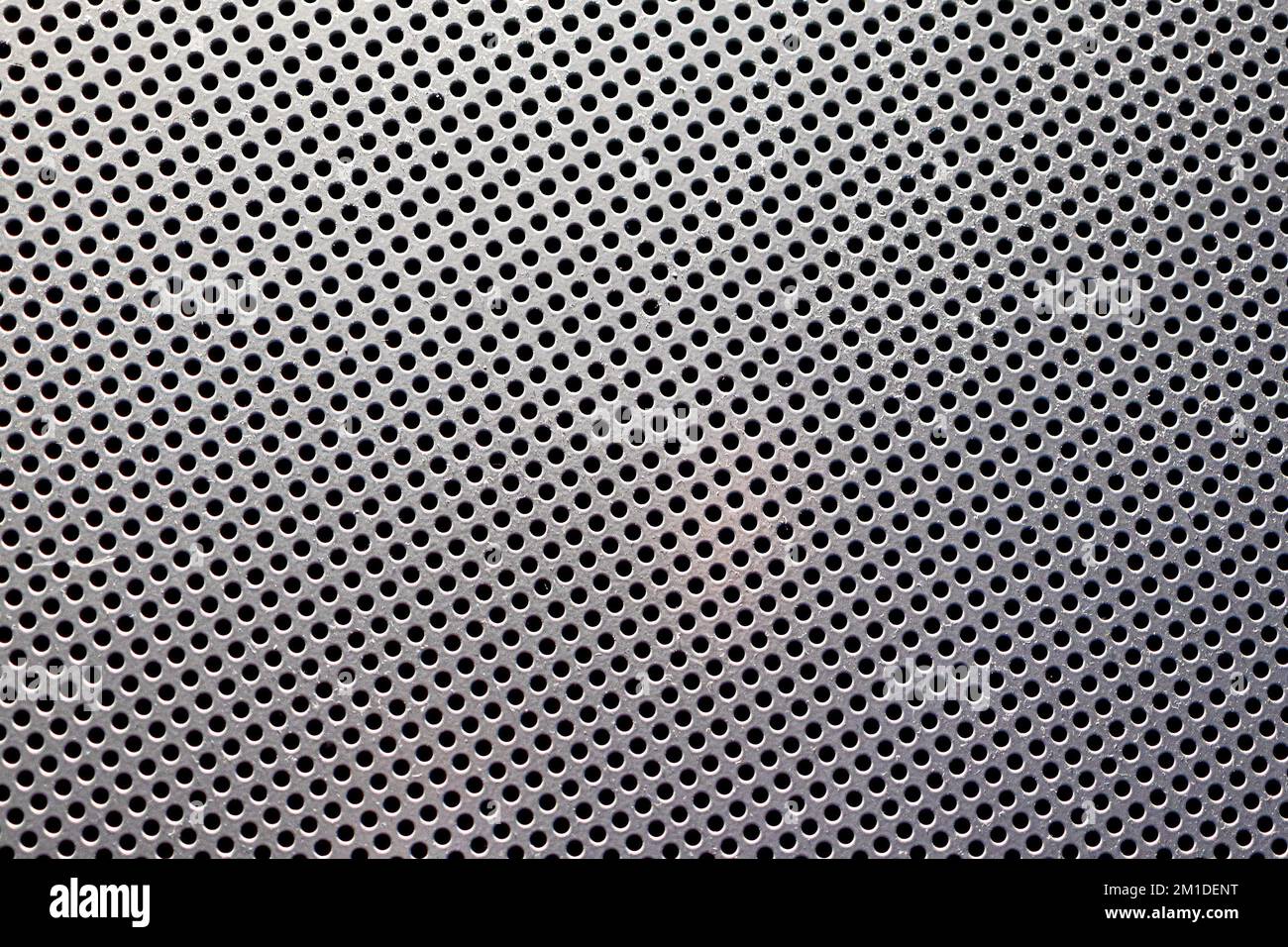 A closeup of a metallic surface with tiny holes for textures and ...