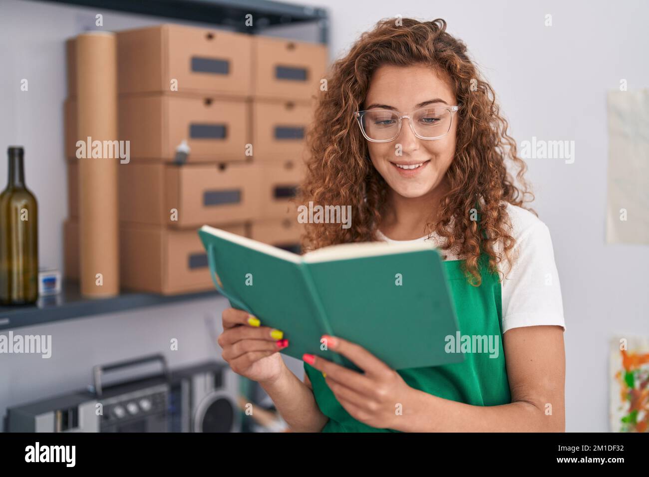 Young beautiful hispanic woman artist smiling confident reading book at ...