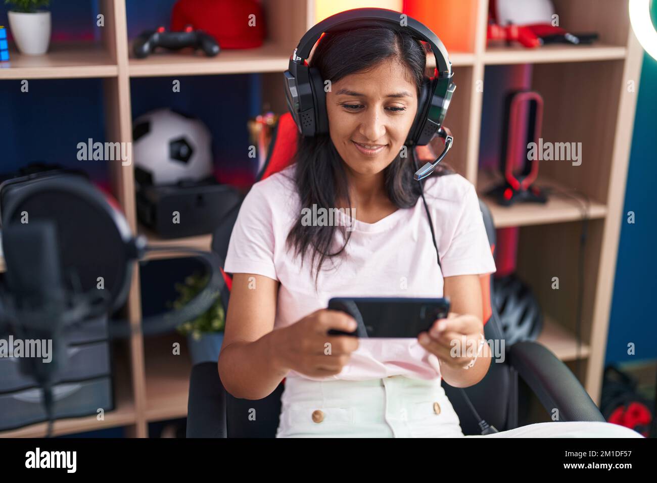 Young beautiful hispanic woman streamer playing video game using ...