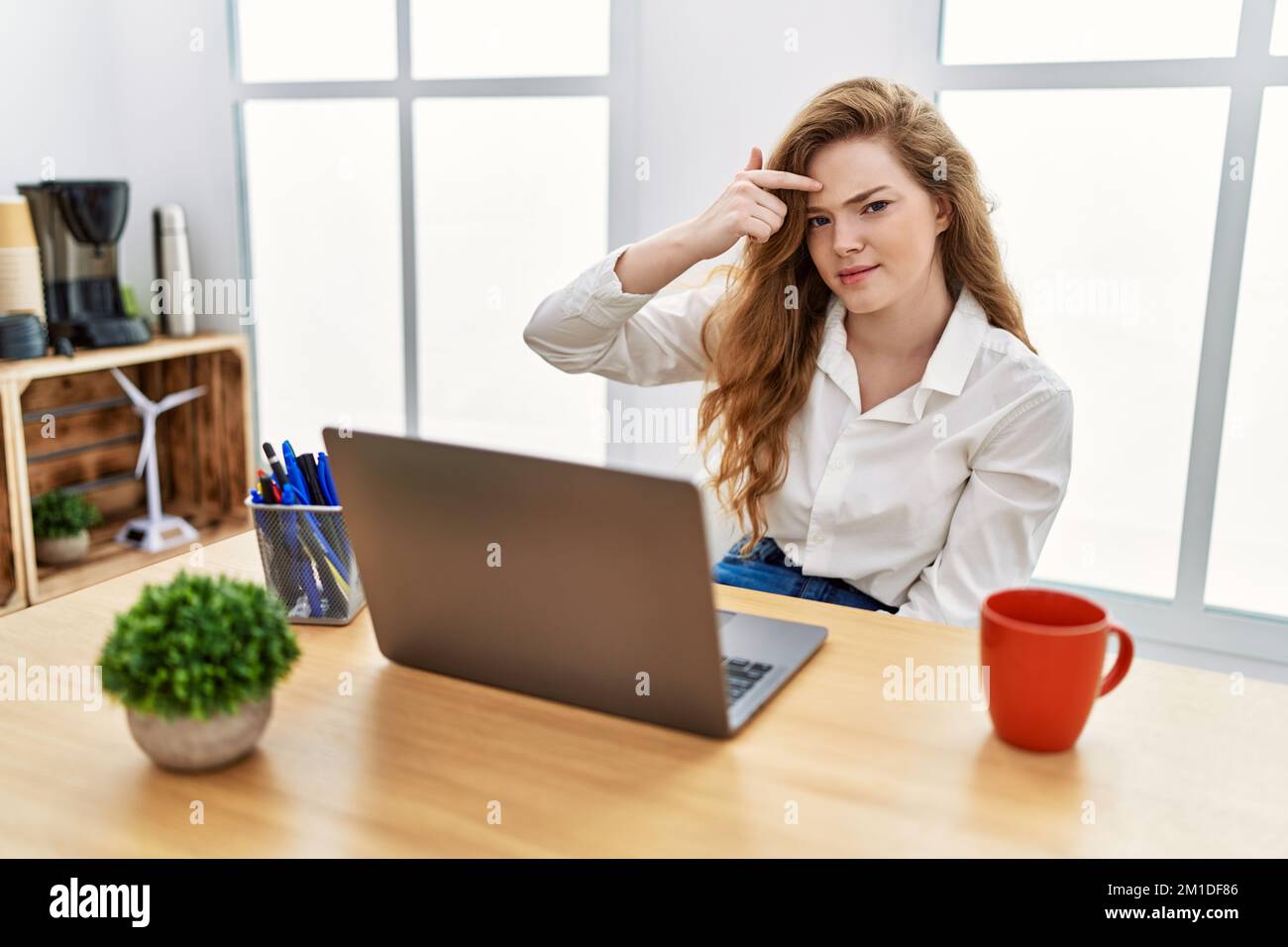 Young caucasian woman working at the office using computer laptop ...