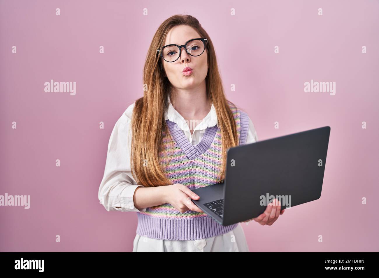 Young caucasian woman working using computer laptop making fish face ...