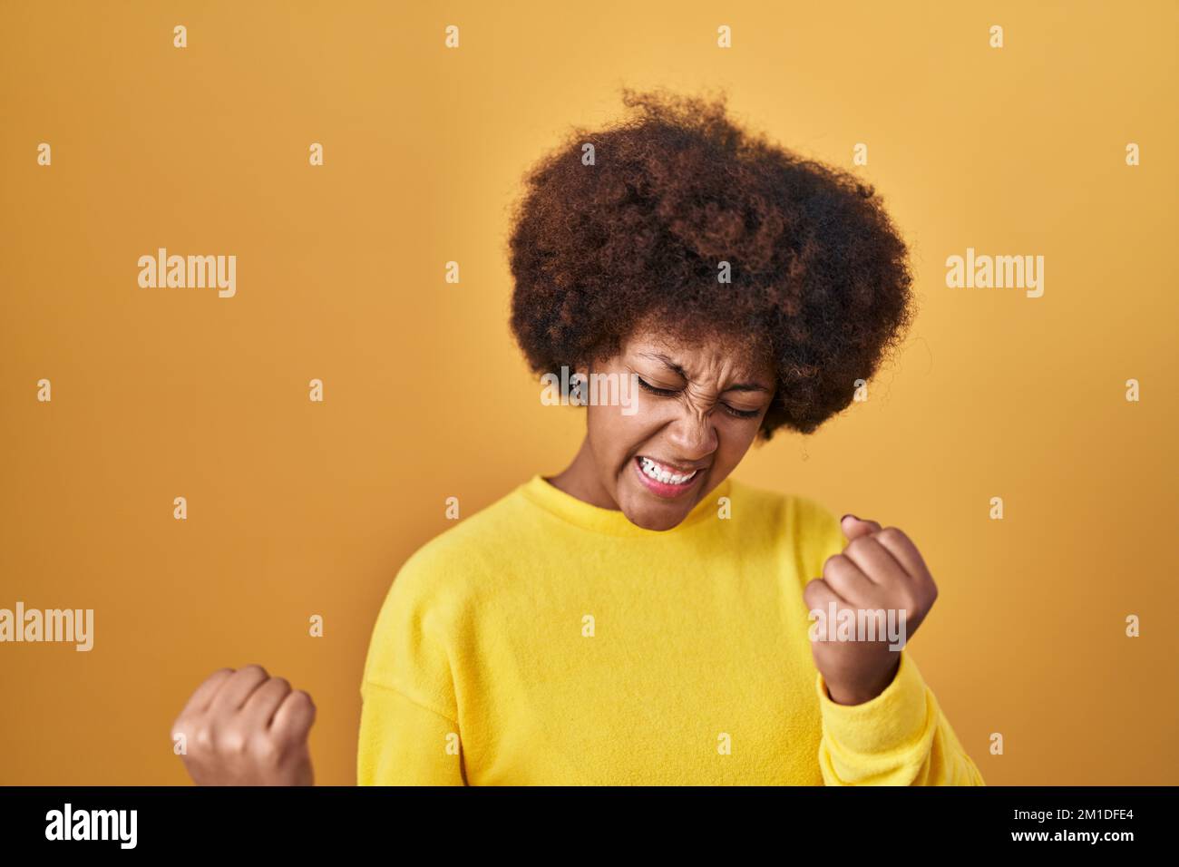 Young african american woman standing over yellow background very happy ...