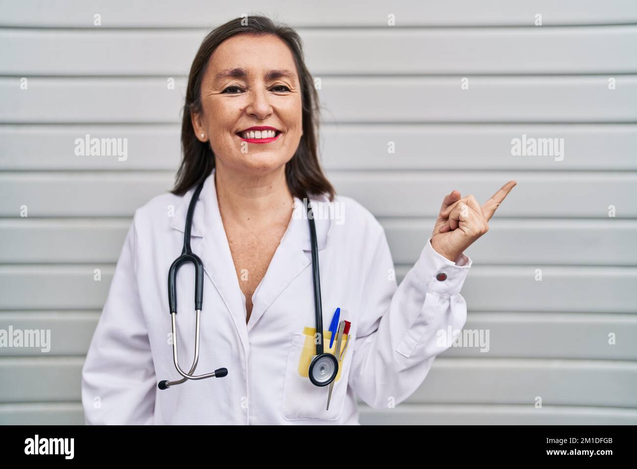 Middle age hispanic woman wearing doctor uniform and stethoscope ...