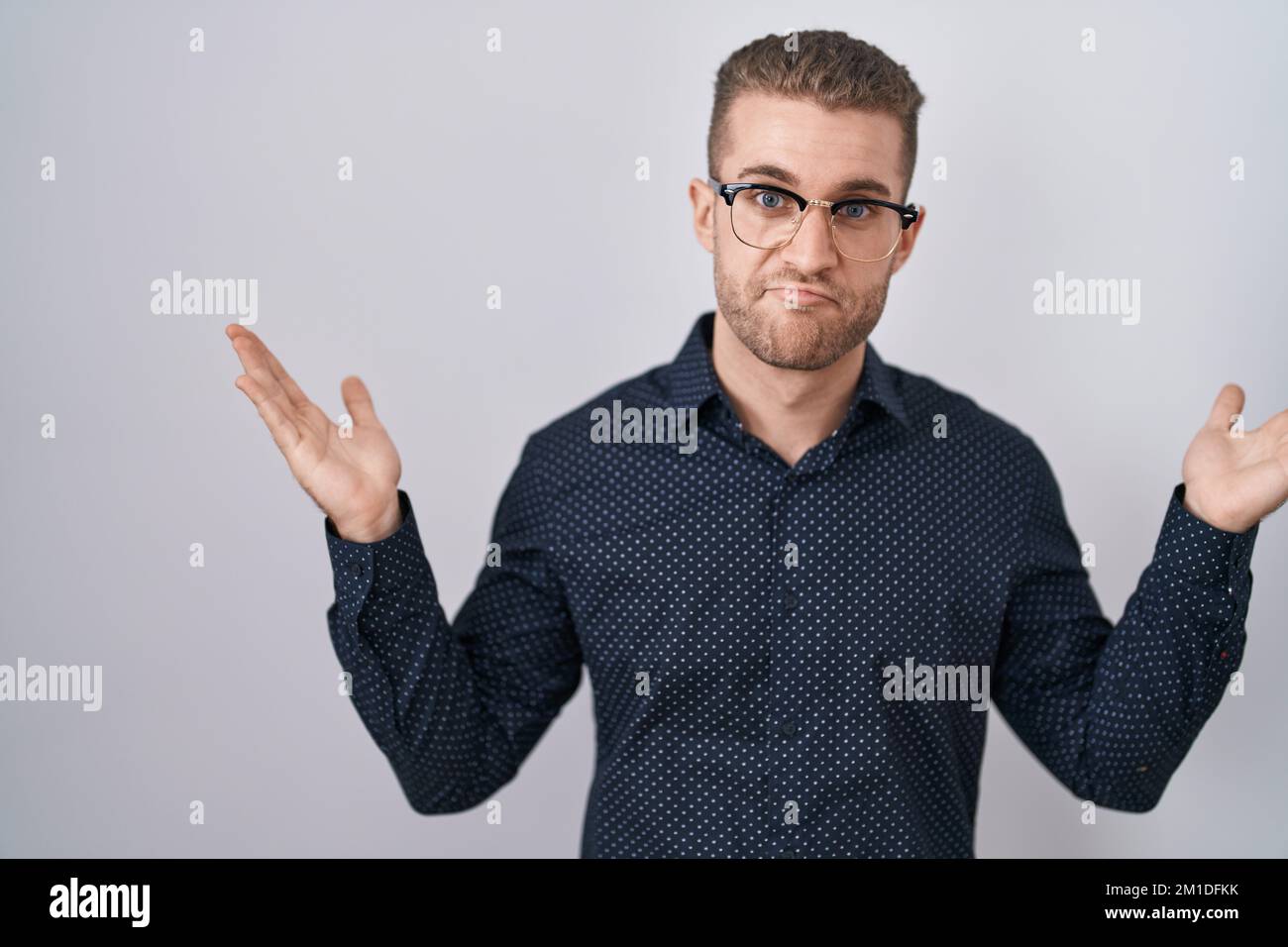 Young caucasian man standing over isolated background clueless and ...