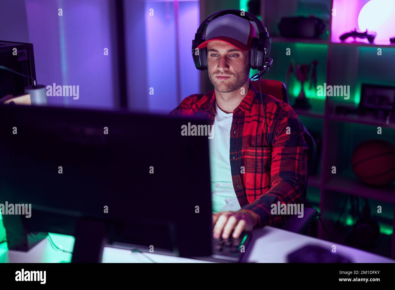 Young caucasian man playing video games thinking attitude and sober ...