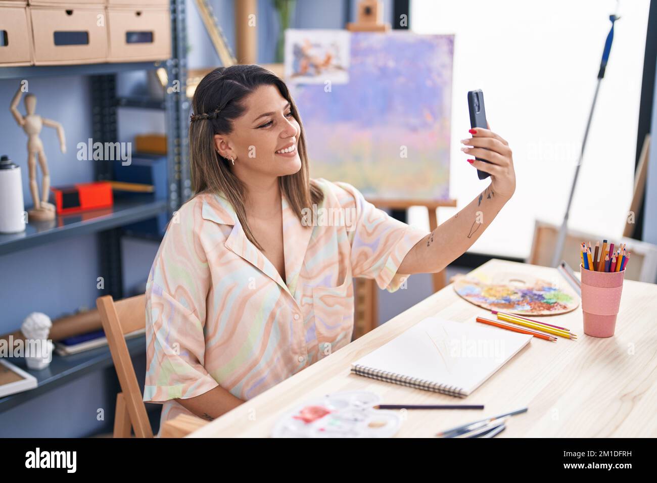 Young hispanic woman artist smiling confident make selfie by smartphone ...