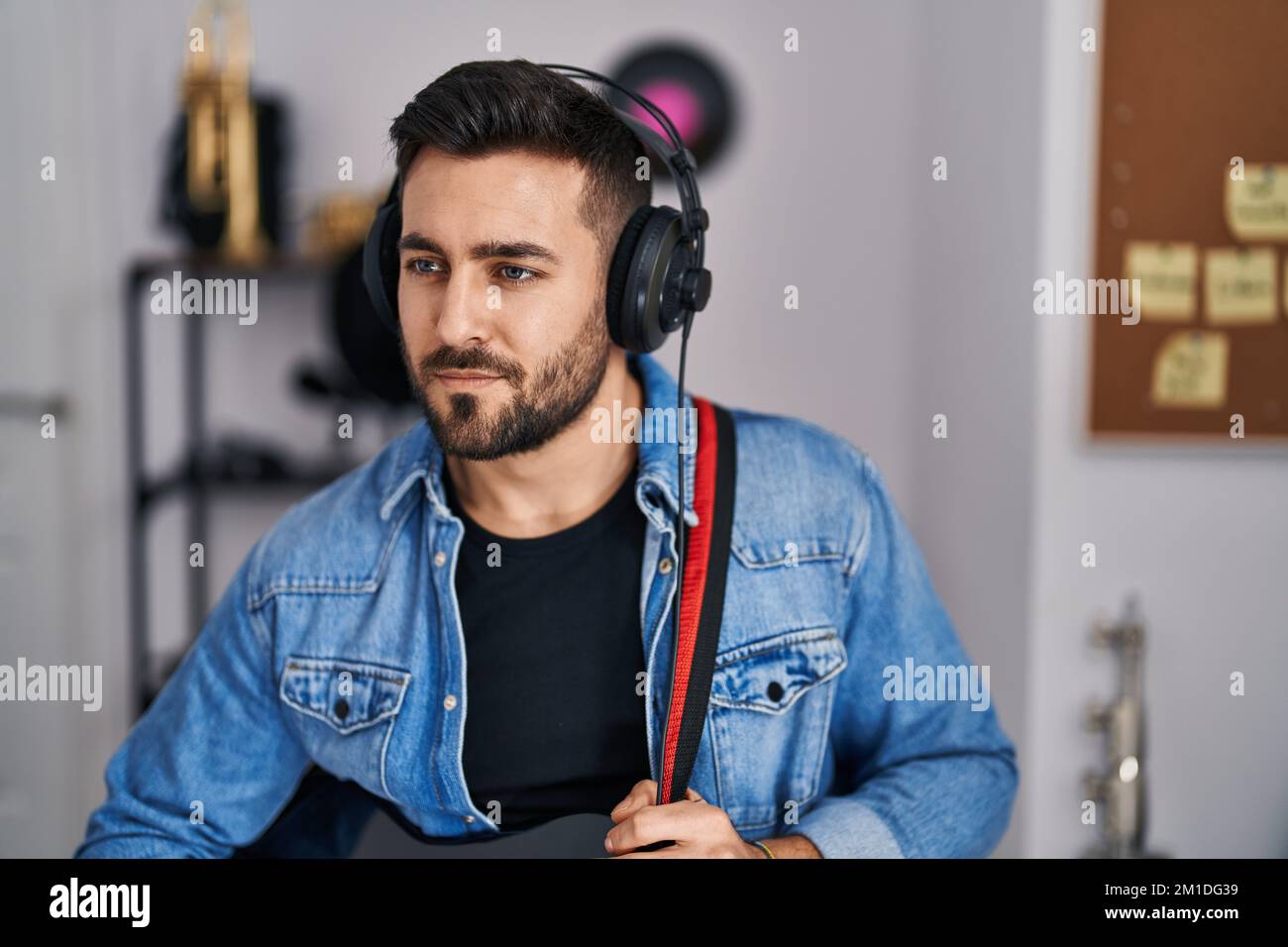 Young hispanic man smiling confident holding electric guitar at music ...