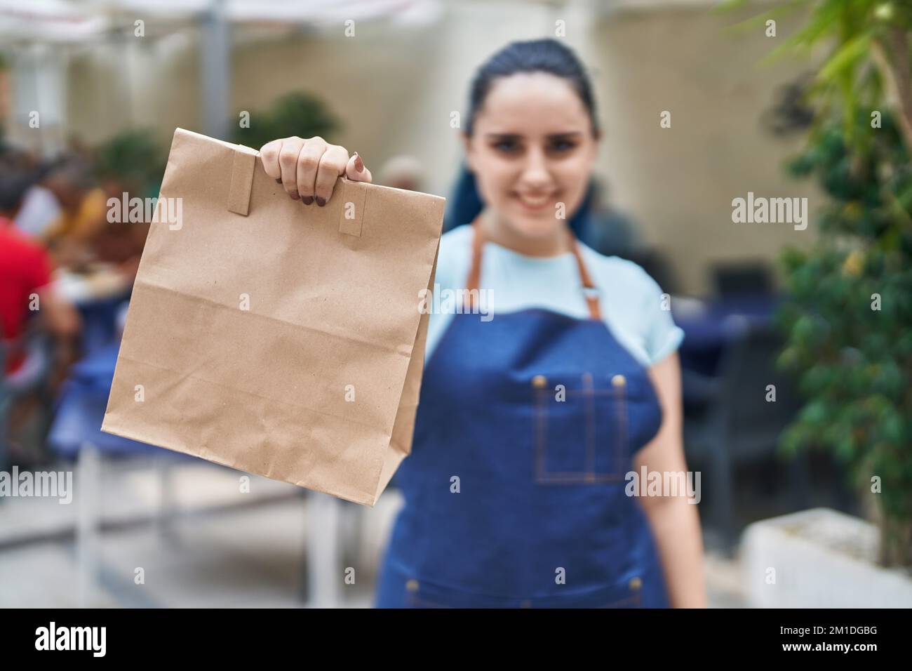 Young caucasian woman waitress smiling confident holding take away food ...