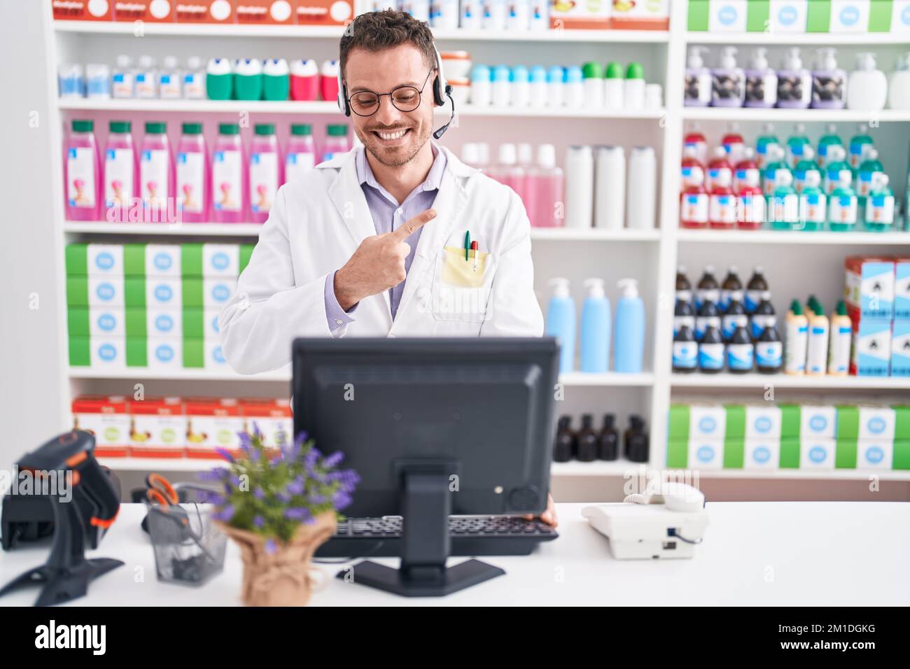 Young hispanic man working at pharmacy drugstore wearing headset ...