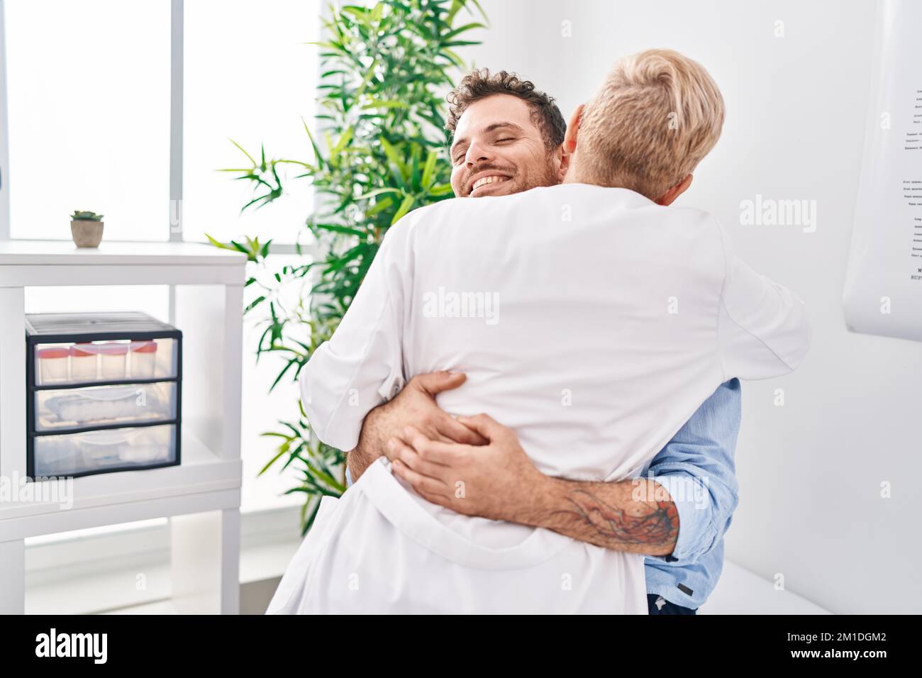 Mother and son patient and doctor hugging each other at clinic Stock ...