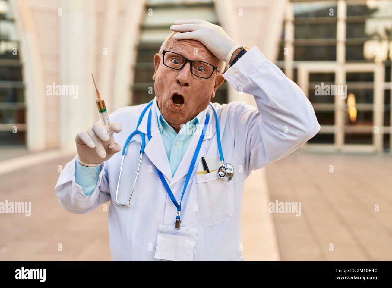 Senior doctor with grey hair holding syringe stressed and frustrated ...
