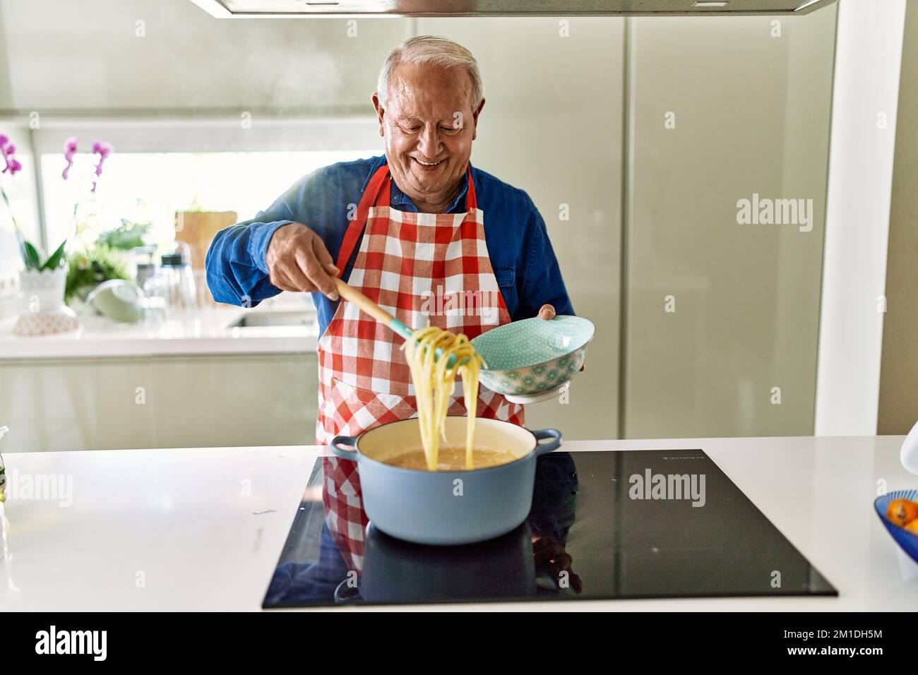 Senior man smiling confident cooking spaghetti at kitchen Stock Photo ...