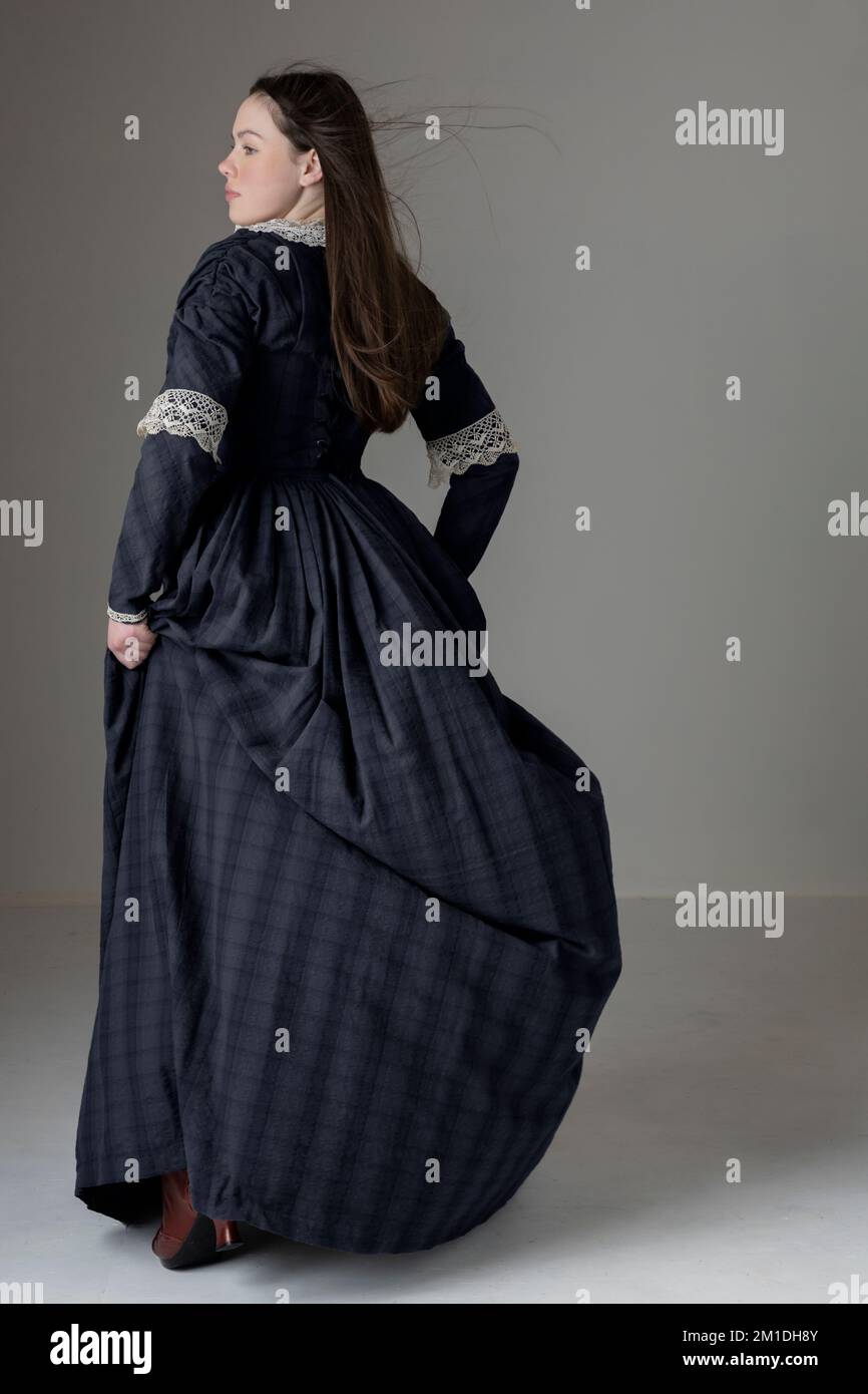 A young Victorian woman wearing a blue cotton dress with lace trim ...