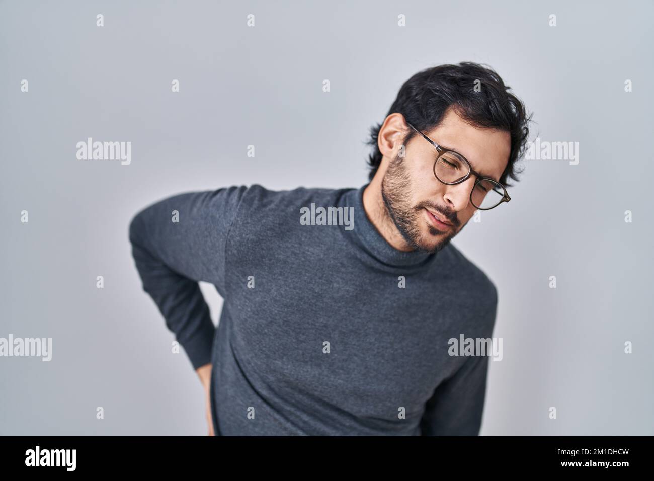 Handsome latin man standing over isolated background suffering of ...