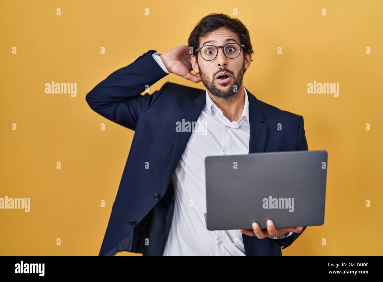 Handsome latin man working using computer laptop crazy and scared with ...