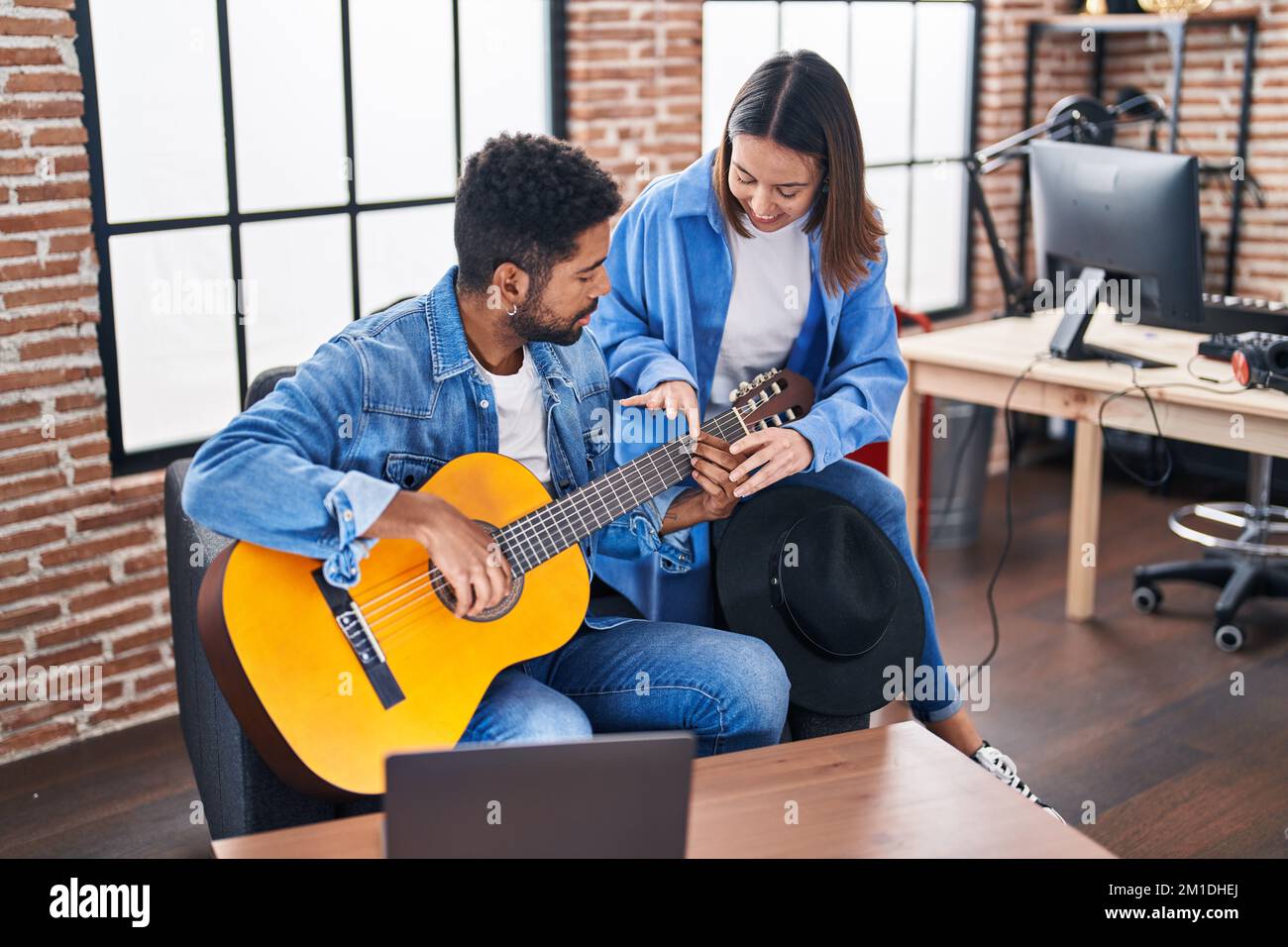 Man and woman musicians having classical guitar lesson at music studio ...