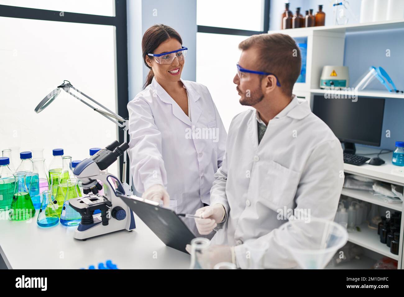 Man and woman scientist partners reading document working at laboratory ...