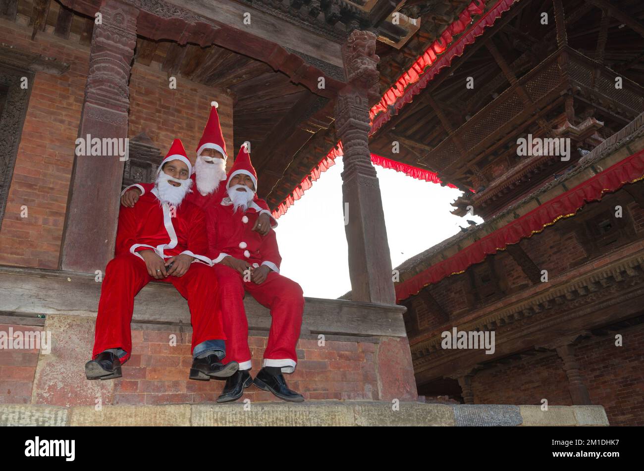 3 local men costumed as Santa Claus sitting on temple steps at Durbar ...