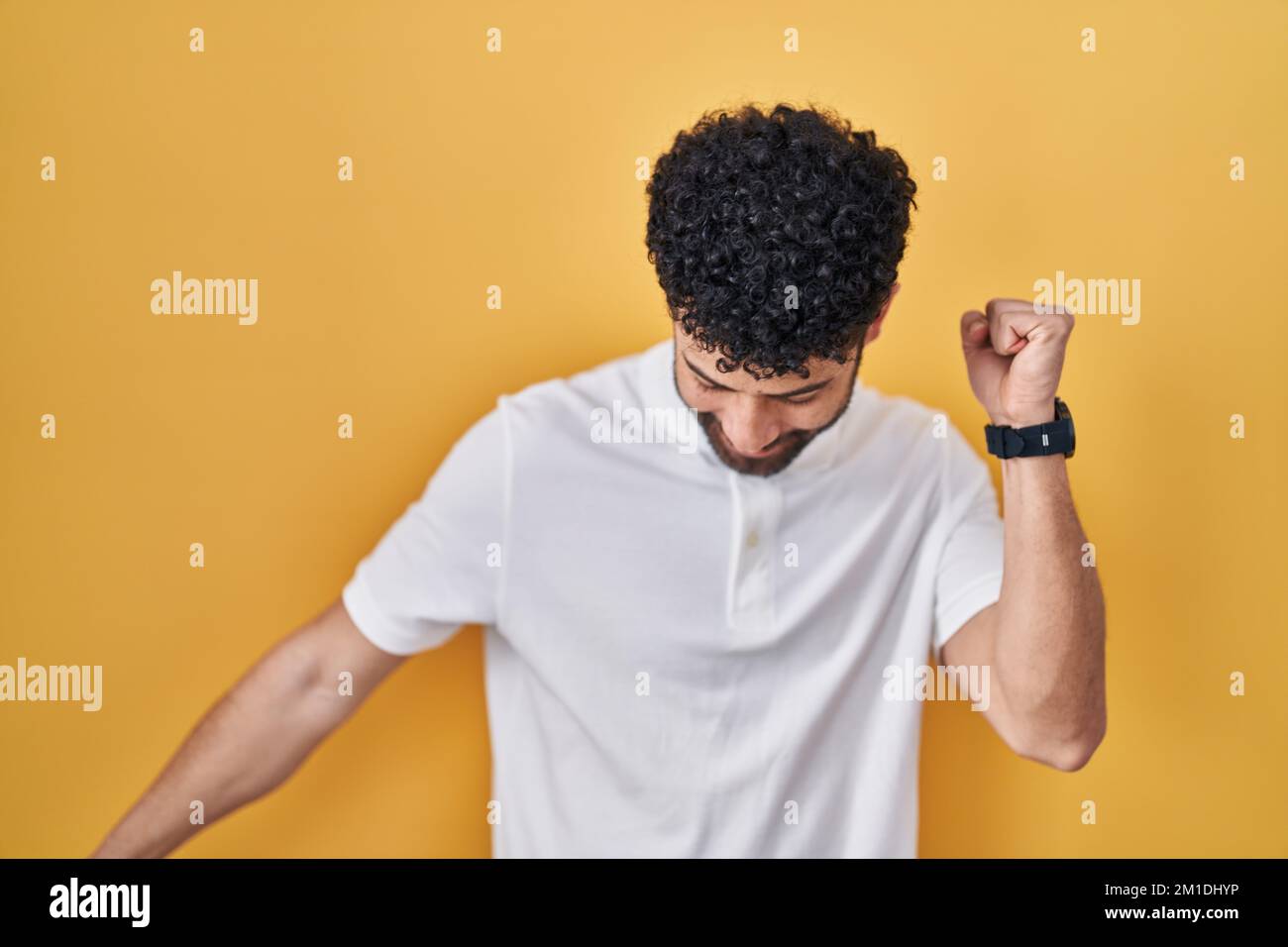 Arab man standing over yellow background dancing happy and cheerful ...