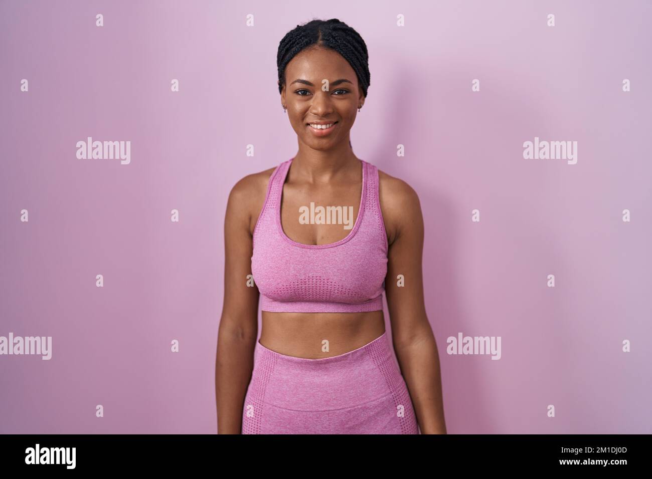African american woman with braids wearing sportswear over pink ...