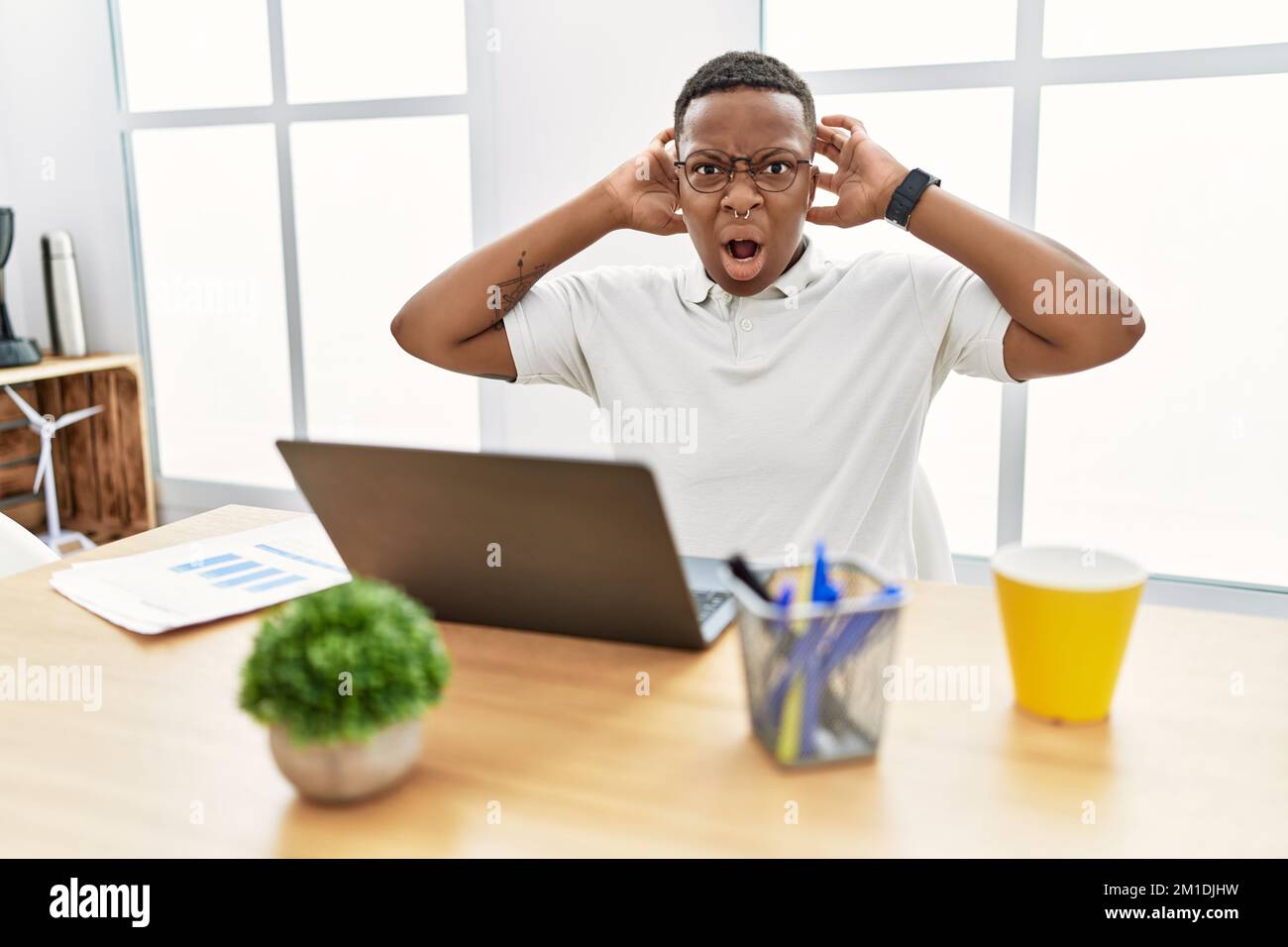 Young african man working at the office using computer laptop crazy and ...
