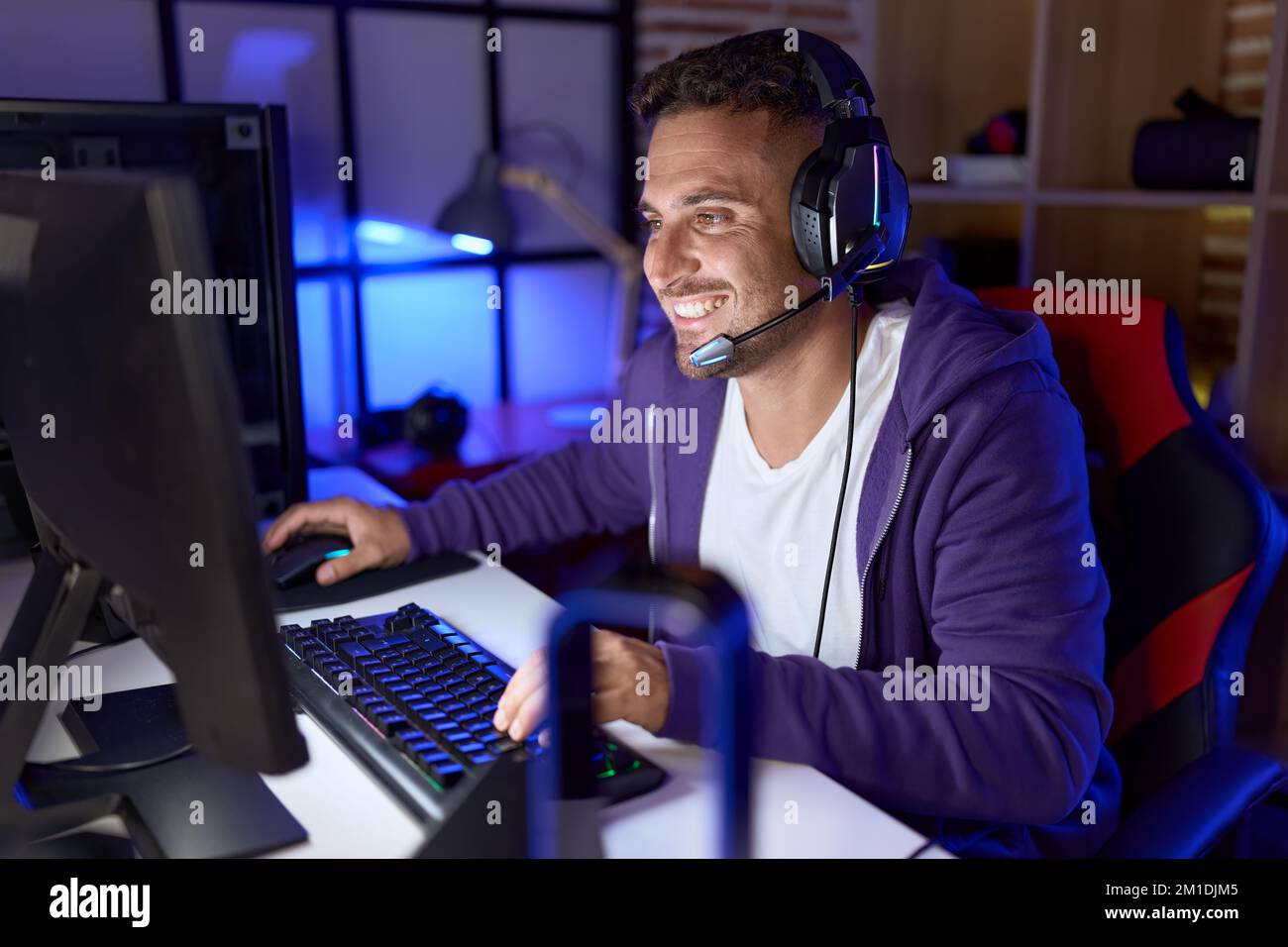 Young hispanic man streamer playing video game using computer at gaming ...