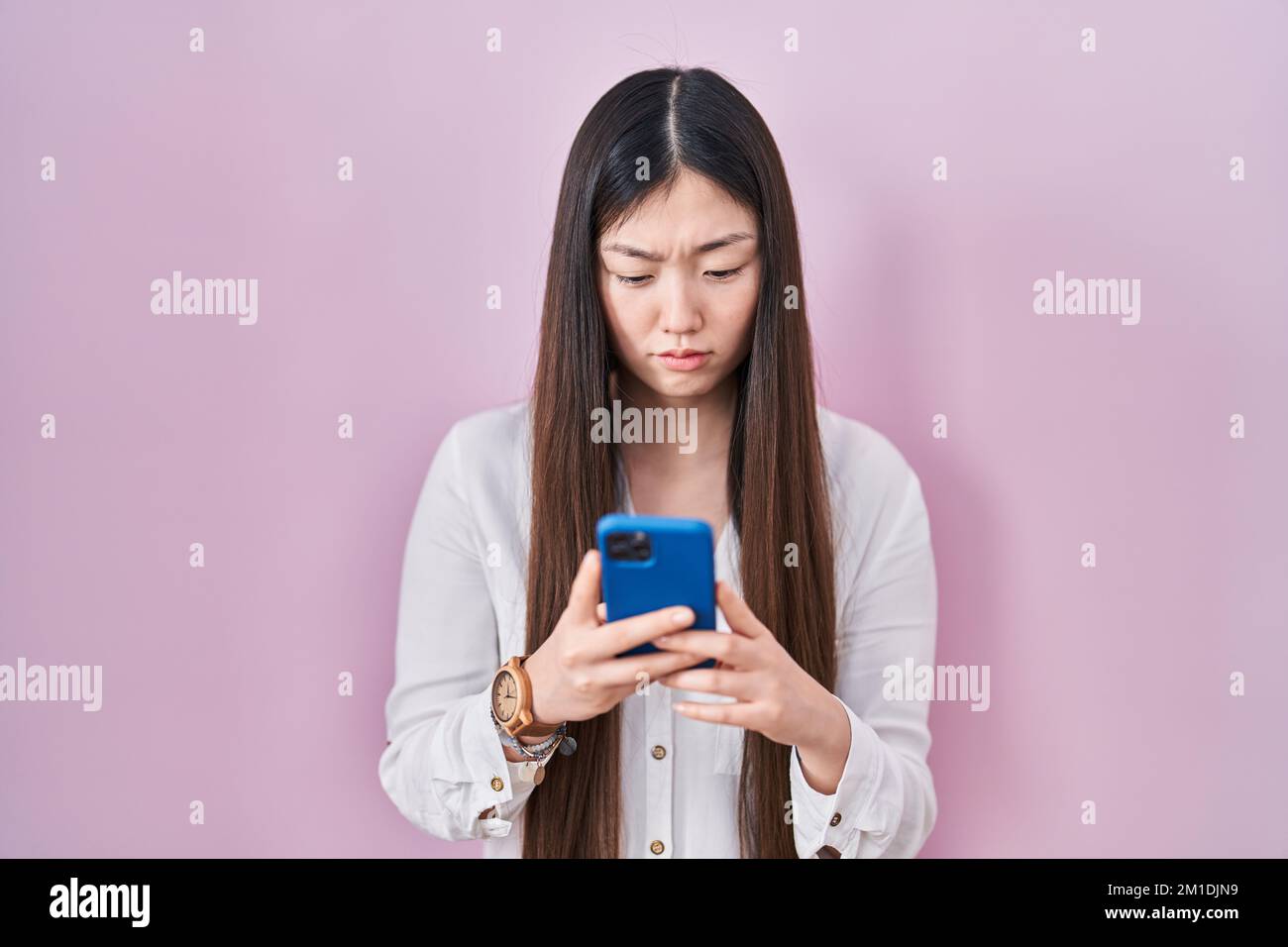Chinese young woman using smartphone typing message depressed and worry ...