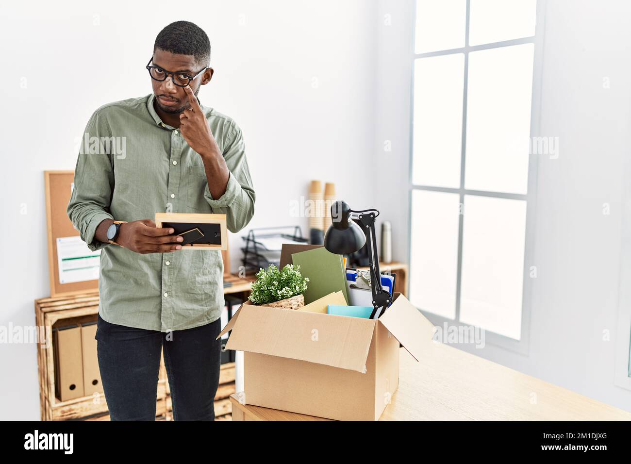 Young african american businessman unboxing box at the office pointing ...