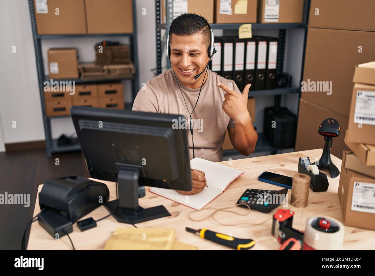 Hispanic young man working at small business ecommerce smiling happy ...