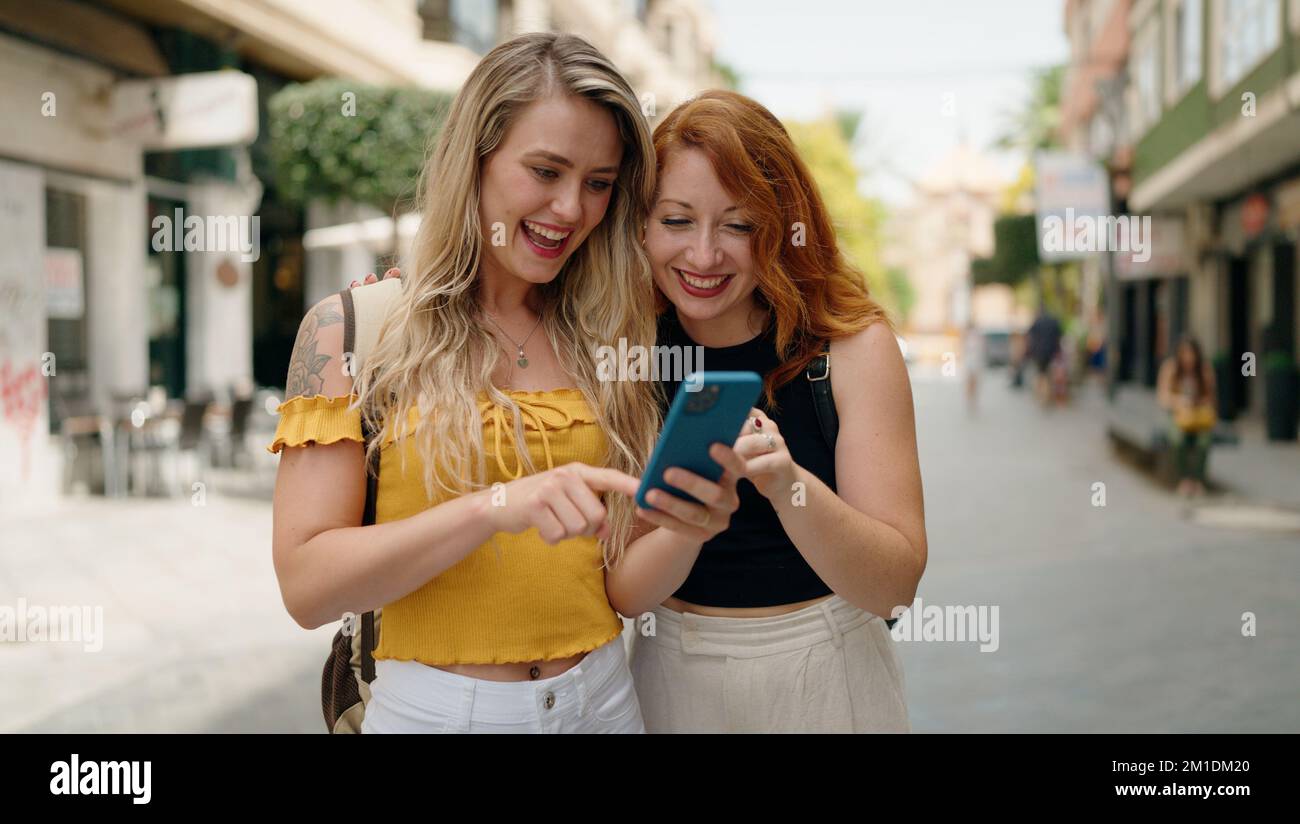 Two women standing together using hi-res stock photography and images ...