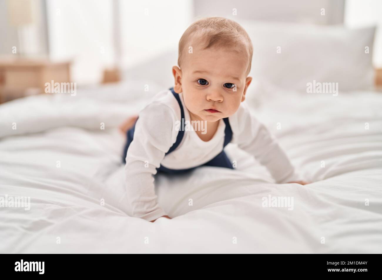 Adorable toddler crawling on bed at bedroom Stock Photo - Alamy