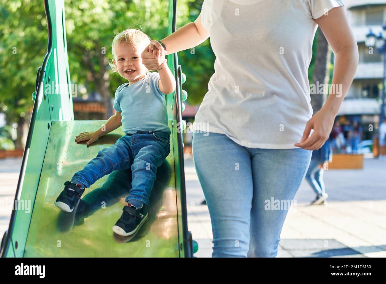Mother and son smiling confident playing on slide at park playground Stock Photo - Alamy