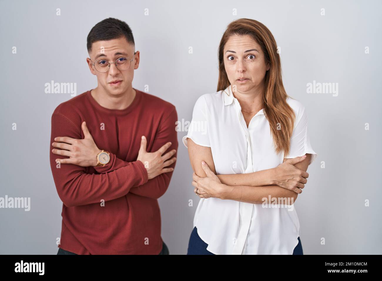 Mother and son standing together over isolated background shaking and ...