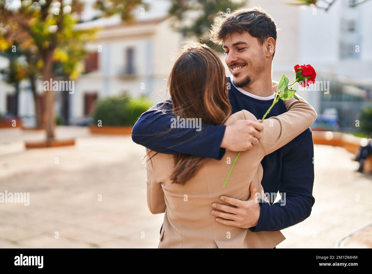 Mand and woman couple hugging each other suprise with rose at park ...