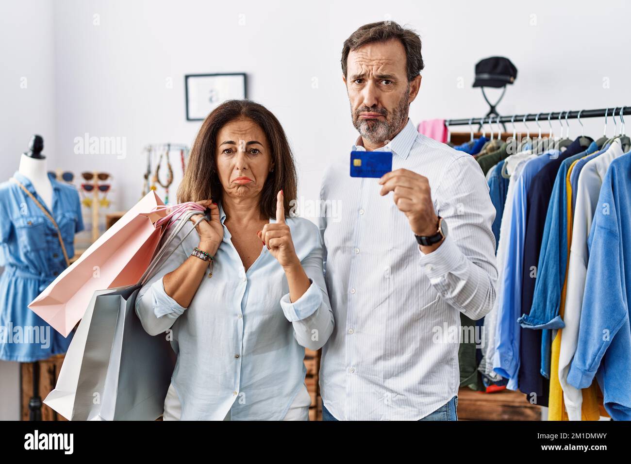 Hispanic middle age couple holding shopping bags and credit card ...